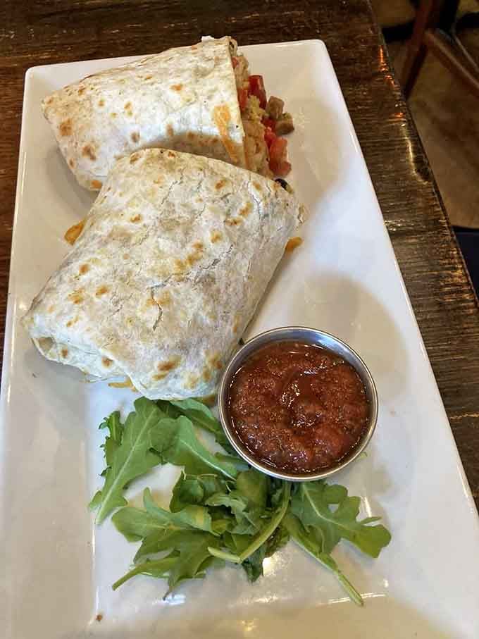 That generously stuffed breakfast burrito with salsa and greens looks like it could fuel your entire day, maybe even tomorrow too.