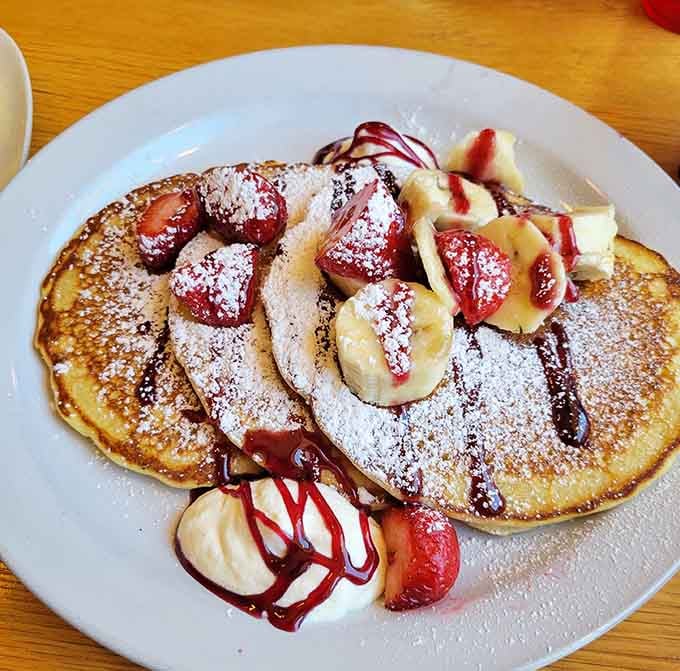 These pancakes arrive looking like edible art, topped with fresh fruit and whipped cream that'll make you forget about IHOP forever.
