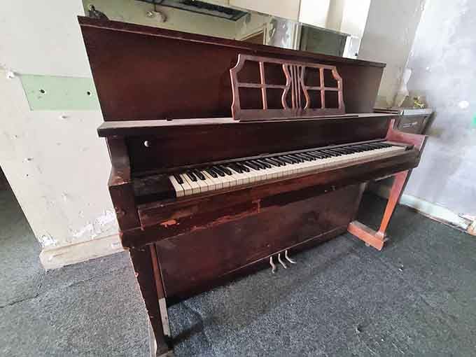 An abandoned piano that once brought music to these halls now sits silent, its keys untouched by time.