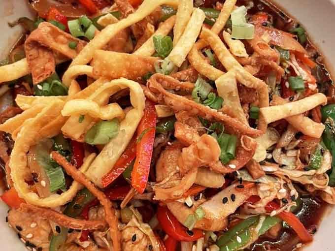 This chicken stir fry arrives piled high enough to make you question physics, portion control, and your dinner plans.