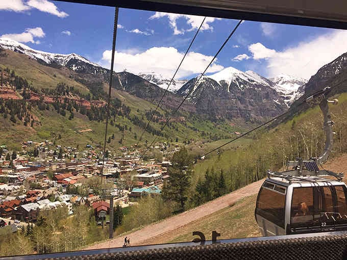 Your gondola view includes snow-capped peaks, aspen forests, and the realization that your commute is deeply inadequate.