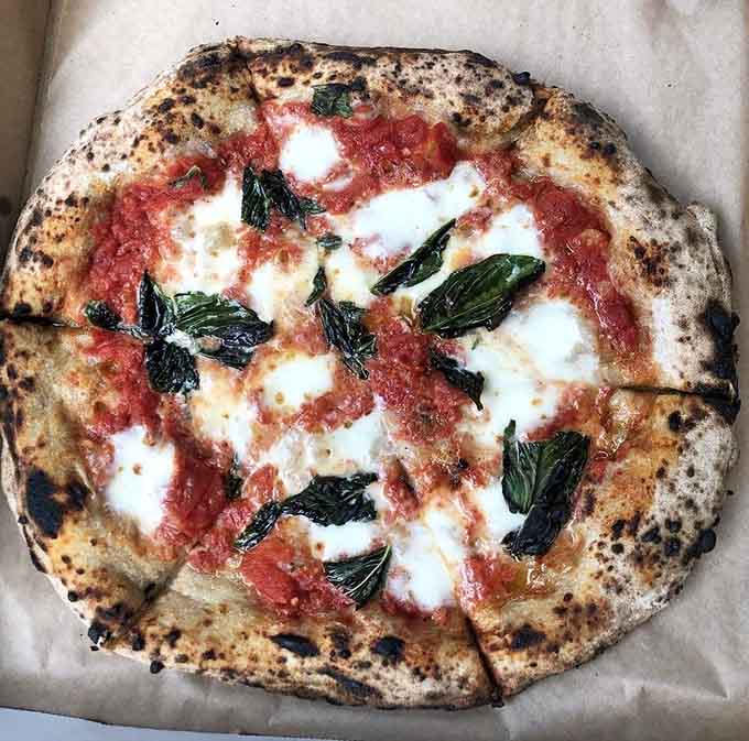 Fresh basil, house-made mozzarella, and that gorgeous leopard-spotted crust show why the classics became classics in the first place.