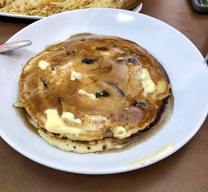 This pancake's golden surface glistening with butter pats and syrup looks like breakfast heaven landed on your plate.