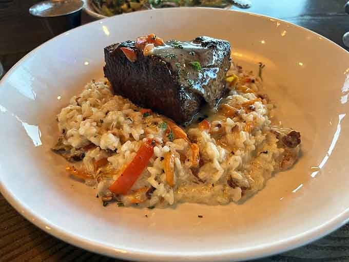 That perfectly cooked ribeye resting on creamy risotto is the kind of plate that makes you pause before diving in.