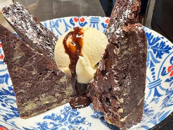 Chocolate cake dusted with powdered sugar and drizzled with sauce, because sometimes dessert is the real reason we're here.