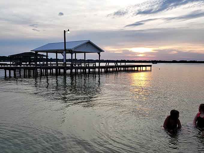 Swimmers enjoying the shallows while sunset approaches captures summer's fleeting magic perfectly and beautifully.