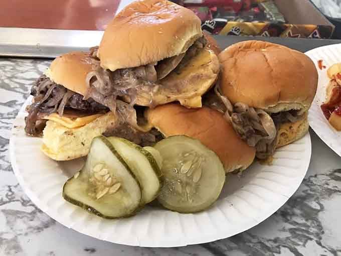 A towering stack of sliders with grilled onions cascading down like a delicious, meaty waterfall of happiness.