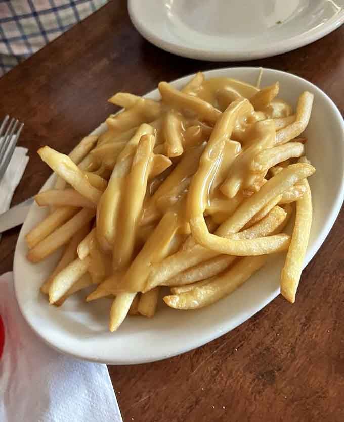 Golden fries swimming in melted cheese, because sometimes you need to live a little dangerously at lunch.