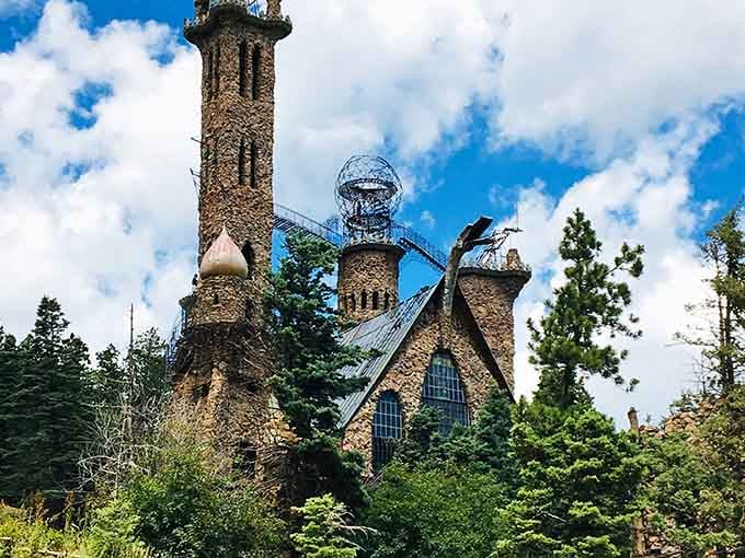 This hand-built stone castle rises from the forest like something Rapunzel ordered from a medieval home improvement catalog gone wonderfully wild.