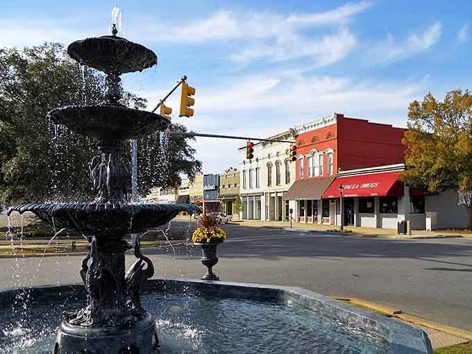 An ornate fountain anchors the town square where water dances and historic storefronts create a postcard-perfect scene.