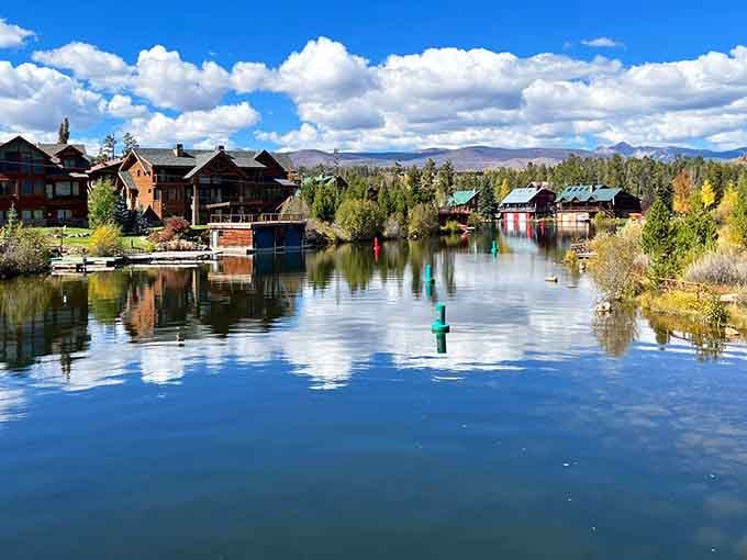 Lakeside homes reflect perfectly in glass-smooth water while autumn aspens paint the shoreline in liquid gold.