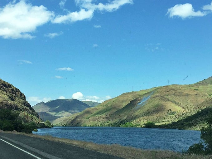 That blue reservoir mirrors the surrounding hills perfectly, creating a double dose of beauty for lucky road trippers.