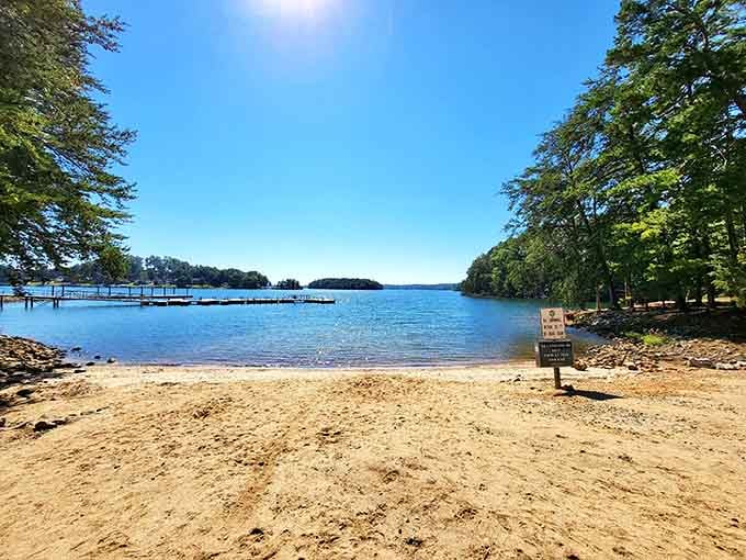 The sandy beach curves gently along the shoreline, inviting barefoot walks and lazy afternoons by the water.