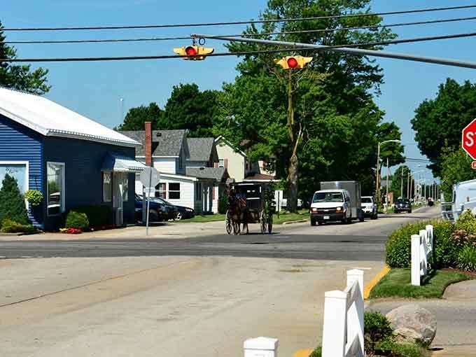 Horse-drawn buggies share the road with cars, creating a living timeline of American transportation history.
