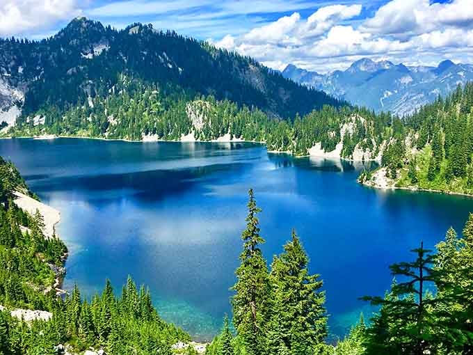 Snow Lake's sapphire waters mirror the surrounding peaks in a reflection so perfect it could fool Narcissus himself.