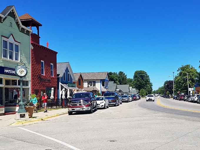 Colorful storefronts pop against blue skies while that charming bell tower watches over the street like a friendly neighborhood guardian.