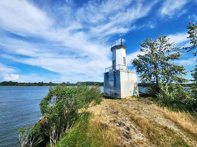 This charming lighthouse perches on its river bluff like a patient guardian, weathered but still standing after all these years.