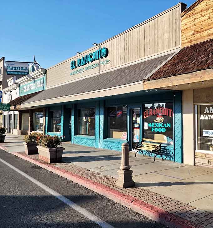 Local shops line the street beneath mountain shadows, offering authentic small-town charm without the tourist trap nonsense.