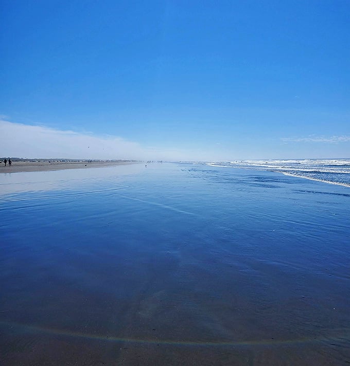The beach becomes a mirror at low tide, reflecting that brilliant blue sky like nature's own infinity pool.