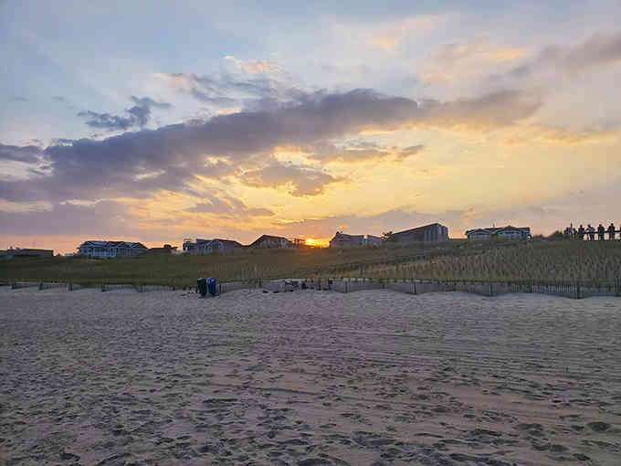 Beach grass sways in evening light as another perfect day ends where sand meets sky in harmony.