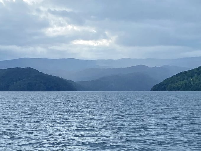 Misty blue mountains layer into the distance like a Bob Ross painting, creating depth that draws your eye forever.