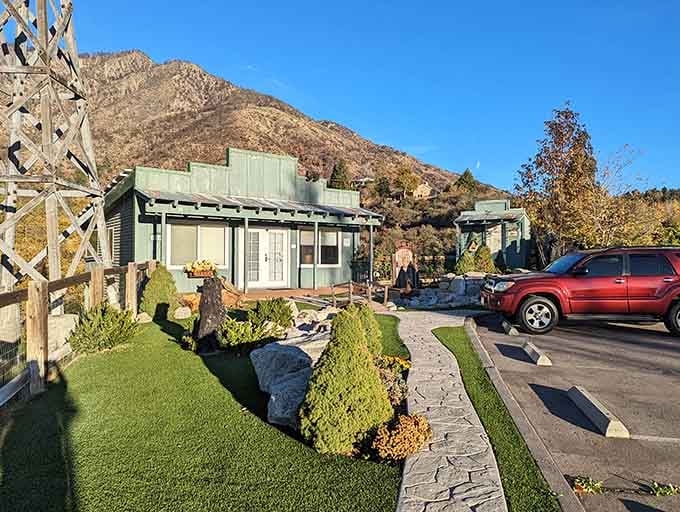 Mountains frame this charming village corner where manicured landscaping meets rugged wilderness in perfect harmony.