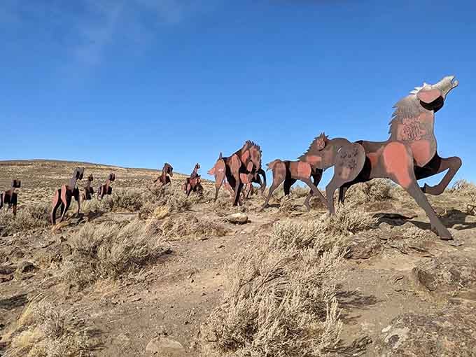 The lead stallion rears dramatically against weathered metal companions, creating a powerful sculpture that celebrates freedom and wild beauty.