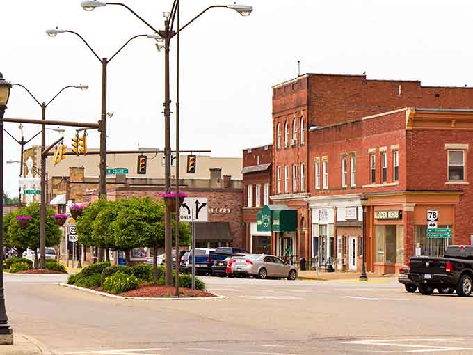 Flower baskets and vintage streetlights add charm to a downtown intersection where rush hour means three cars waiting.
