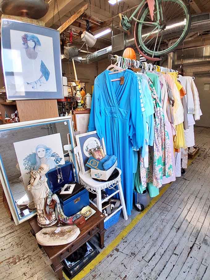 Vintage clothing hangs beneath a bicycle suspended from the ceiling because why not embrace the wonderfully weird?