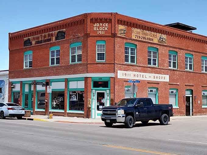 The Steam Train Hotel's brick facade recalls 1911 glory days when railroads ruled and travelers needed comfortable beds nearby.