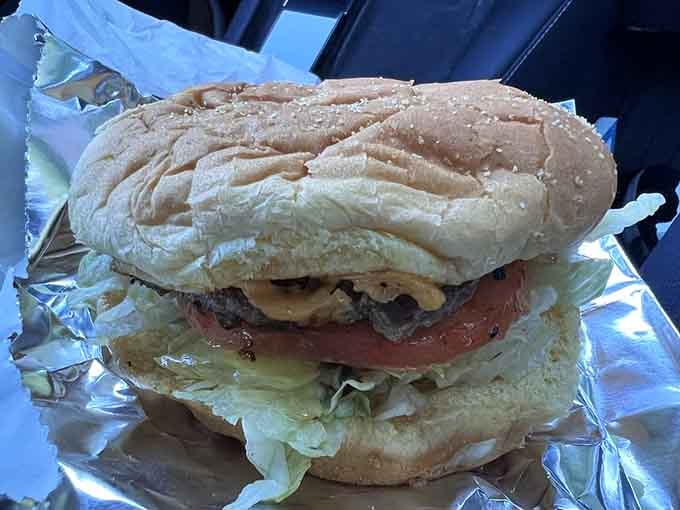 A classic cheeseburger done right, with crisp lettuce and fresh tomato nestled against perfectly melted American cheese slices.