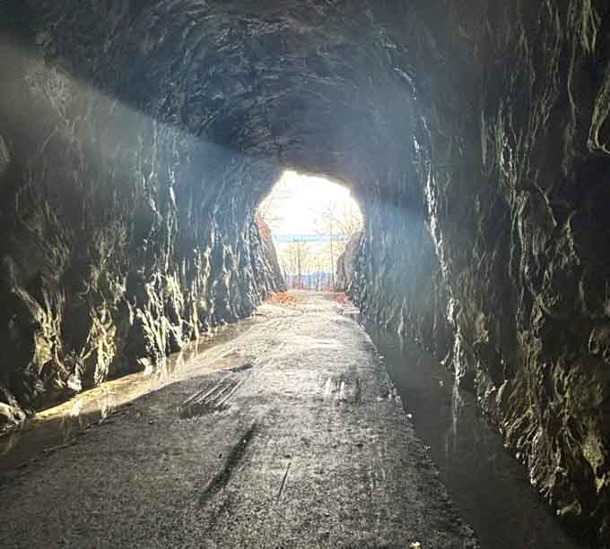 That pinpoint of daylight at tunnel's end feels like hope itself, guiding you through the cool darkness ahead.