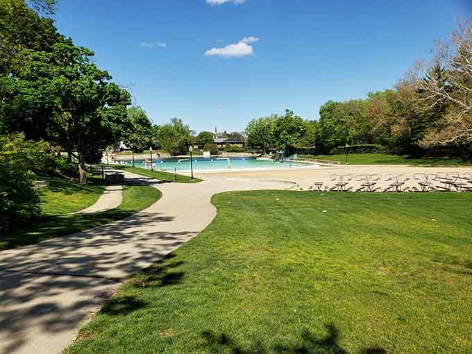 Winding pathways lead past pristine lawns toward that stunning turquoise water, building anticipation with every step closer to the quarry's edge.
