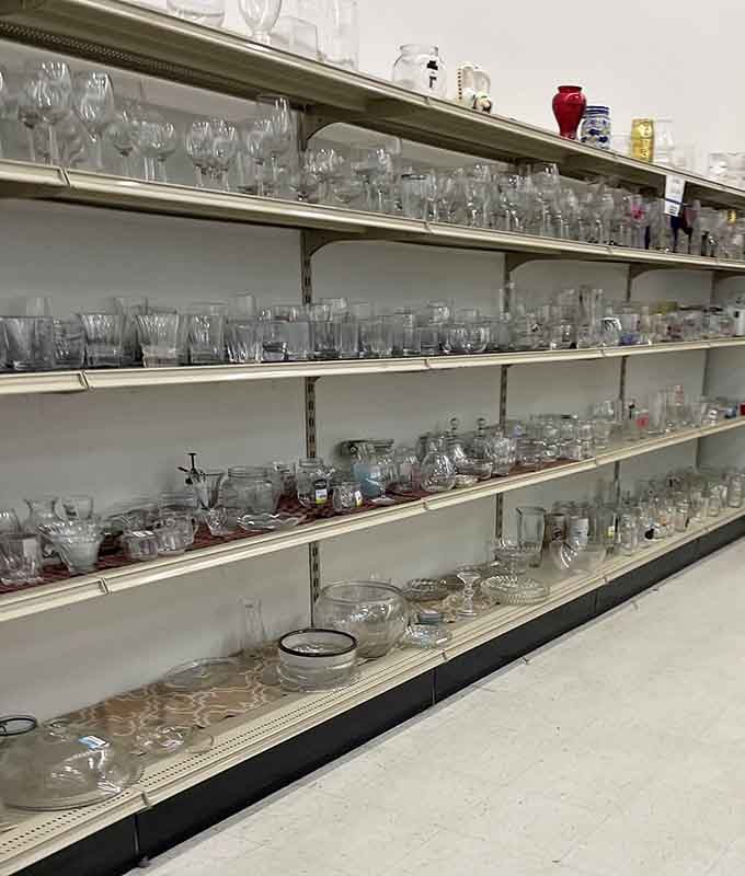 Crystal and glassware sparkle under fluorescent lights, waiting to elevate your next dinner party with vintage elegance.