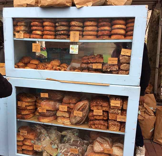 Fresh bread and bagels stacked like edible architecture, still warm enough to make your reusable bag smell amazing.
