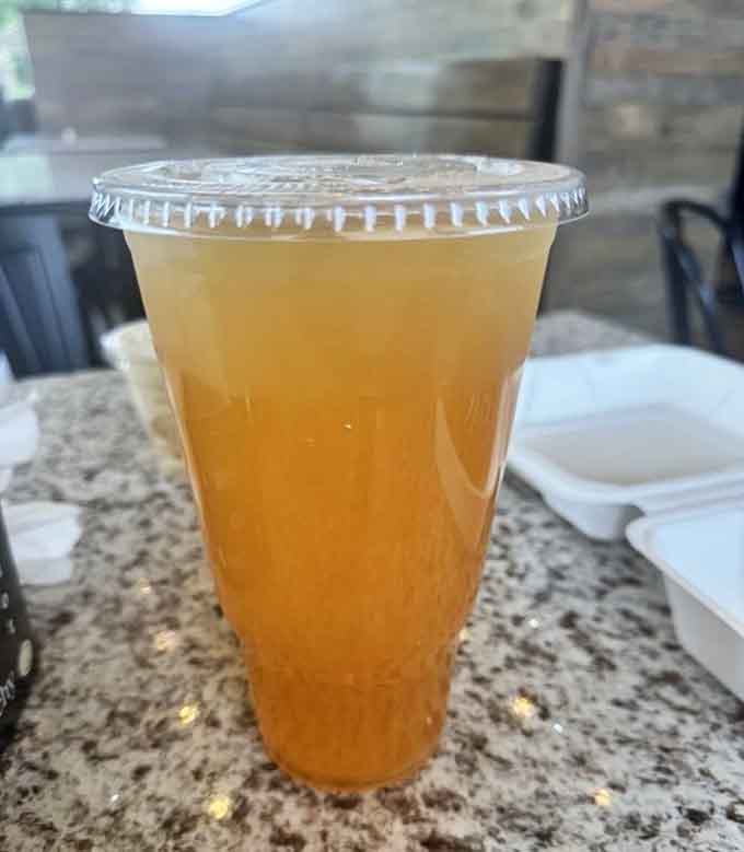 Fresh lemonade in a clear cup promises the perfect sweet refreshment to balance all that savory goodness.
