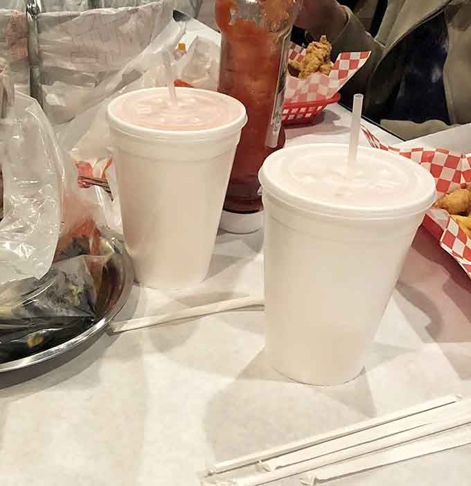 Cold drinks and hot sauce bottles standing ready, because every great seafood feast needs proper liquid reinforcement.