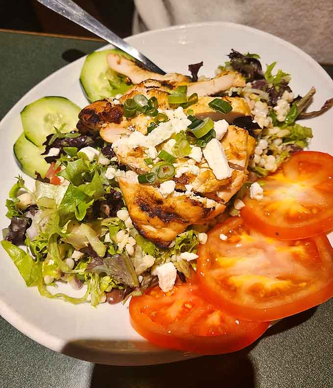 Grilled chicken atop fresh greens with feta and vegetables—proof that salads can be just as exciting as sandwiches.
