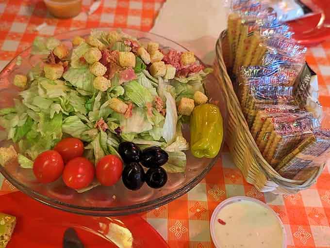 Fresh greens, bright tomatoes, and golden croutons remind us that balance exists, even in pizza palaces.