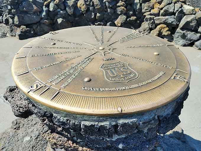 This bronze compass points toward peaks and history, marking where Earth met space program ambitions perfectly.