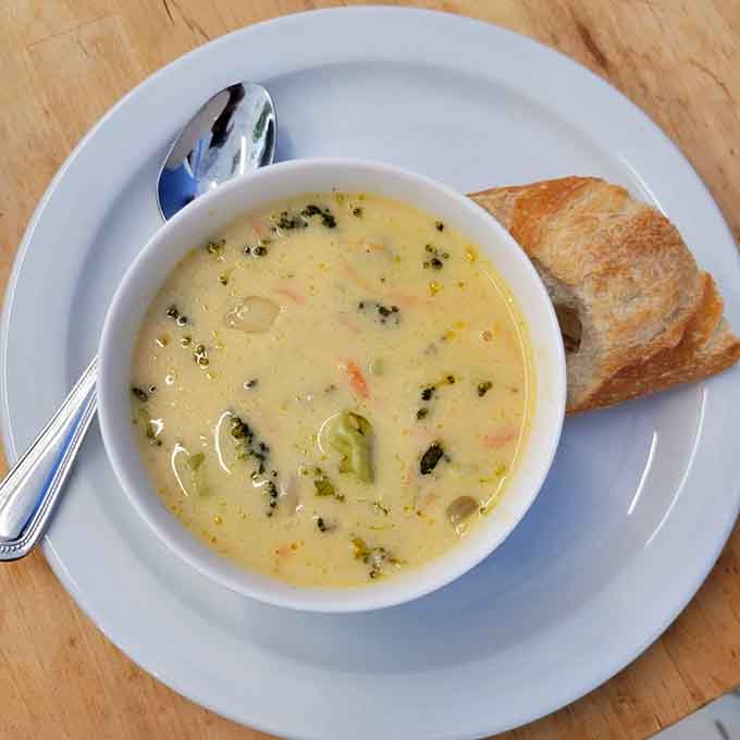 Creamy broccoli cheddar soup with crusty bread: comfort food that gives you a warm hug from within.