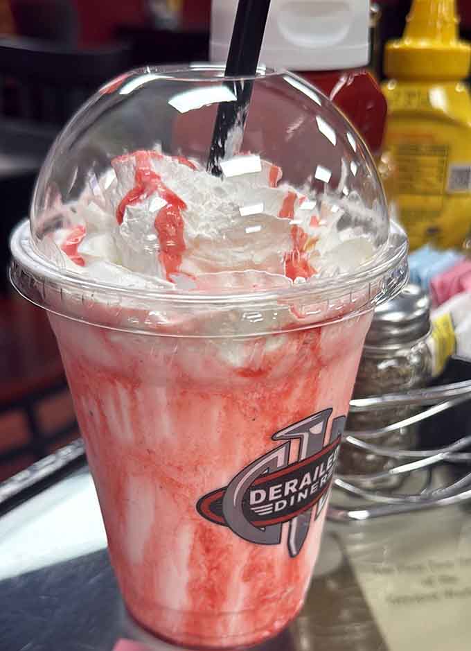That pink milkshake topped with whipped cream is basically childhood in a cup with a straw.