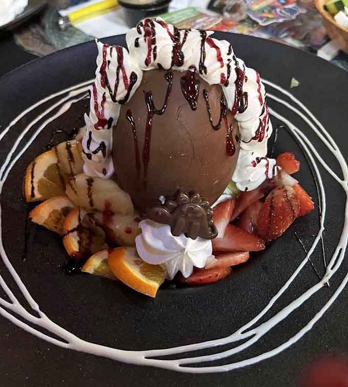 A chocolate dessert egg surrounded by whipped cream and fruit, because extinction doesn't apply to great ideas.