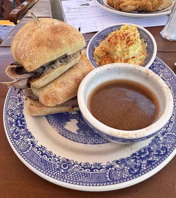 Hot beef sandwich swimming in gravy alongside au gratin potatoes that could convert any carb-skeptic immediately.