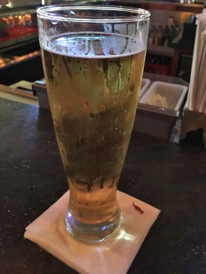 A cold beer waiting patiently at the bar, ready to complement whatever wing adventure you're about to embark upon tonight.