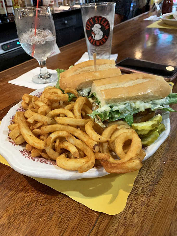 A burger so substantial it requires architectural planning before that first bite, complete with curly fries.