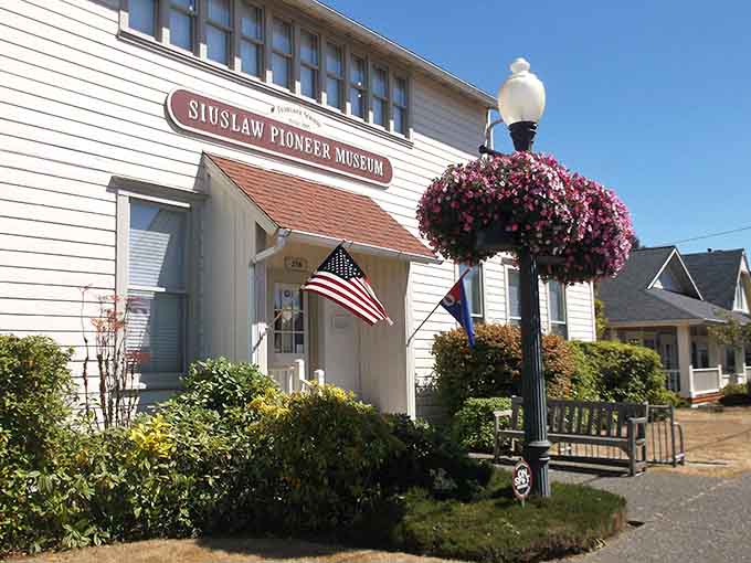 The Siuslaw Pioneer Museum's cheerful facade and blooming baskets welcome history buffs seeking stories from simpler times.