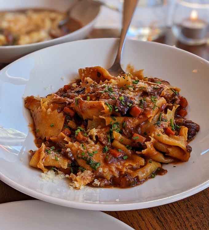 Pappardelle ribbons catching every bit of sauce like they were designed by Italian engineers for maximum flavor delivery.