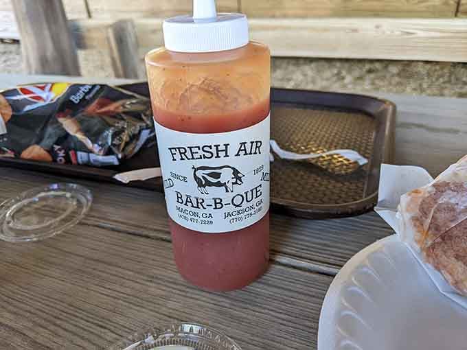 Their signature sauce in a squeeze bottle, ready to add that perfect tangy kick to already spectacular smoked meat perfection.