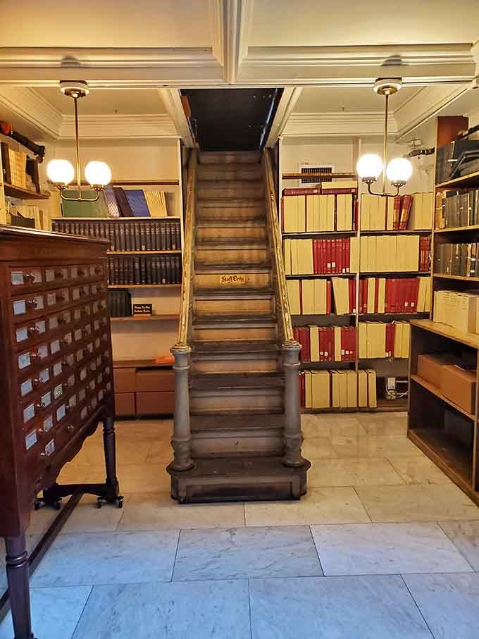 Narrow wooden stairs disappear mysteriously upward, flanked by volumes that have witnessed generations of curious minds passing through.